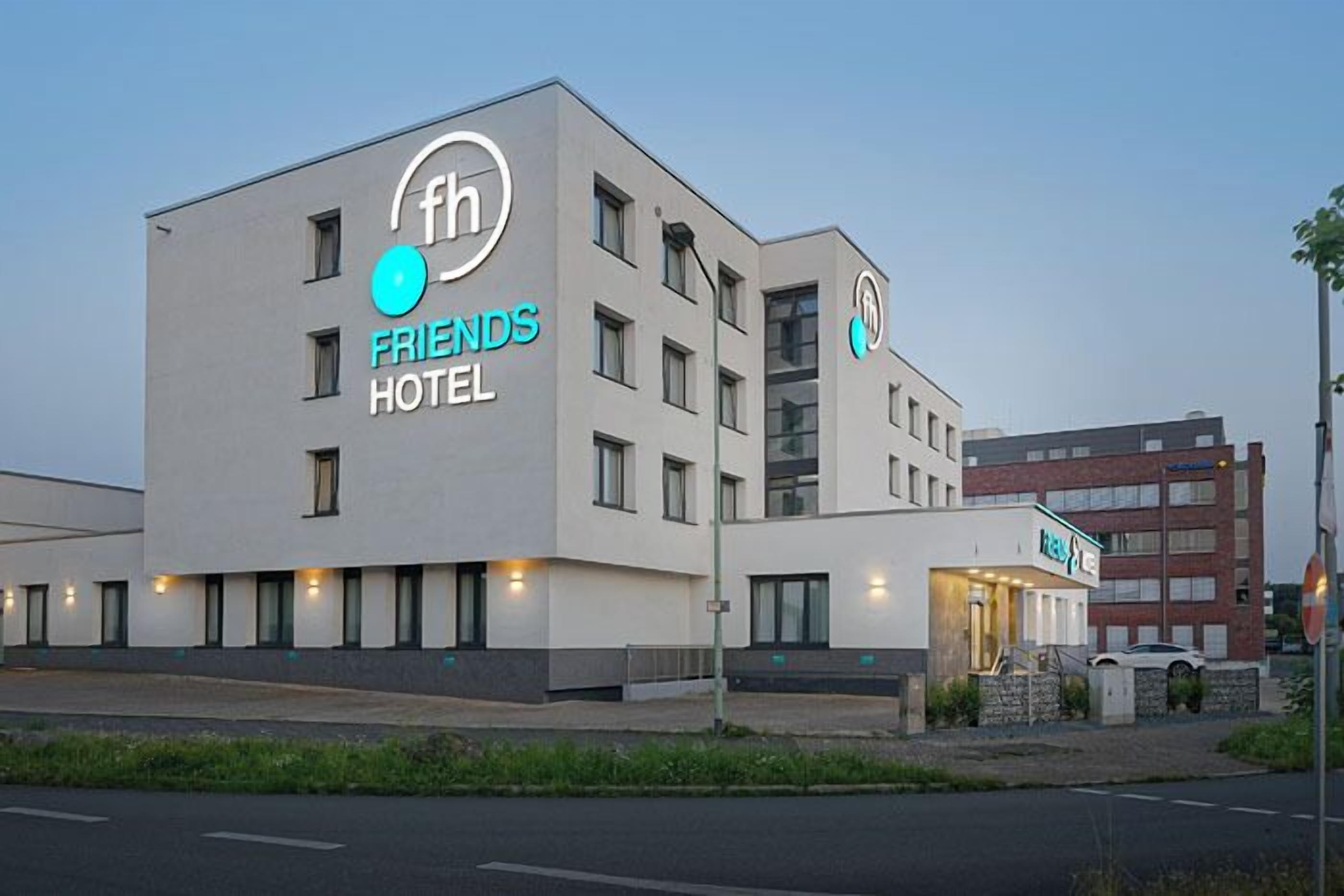 Um edifício moderno com uma placa indicando 'Friends Hotel'.