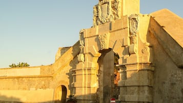 Edifício de pedra com um arco grande e uma placa com um círculo vermelho e uma barra branca.