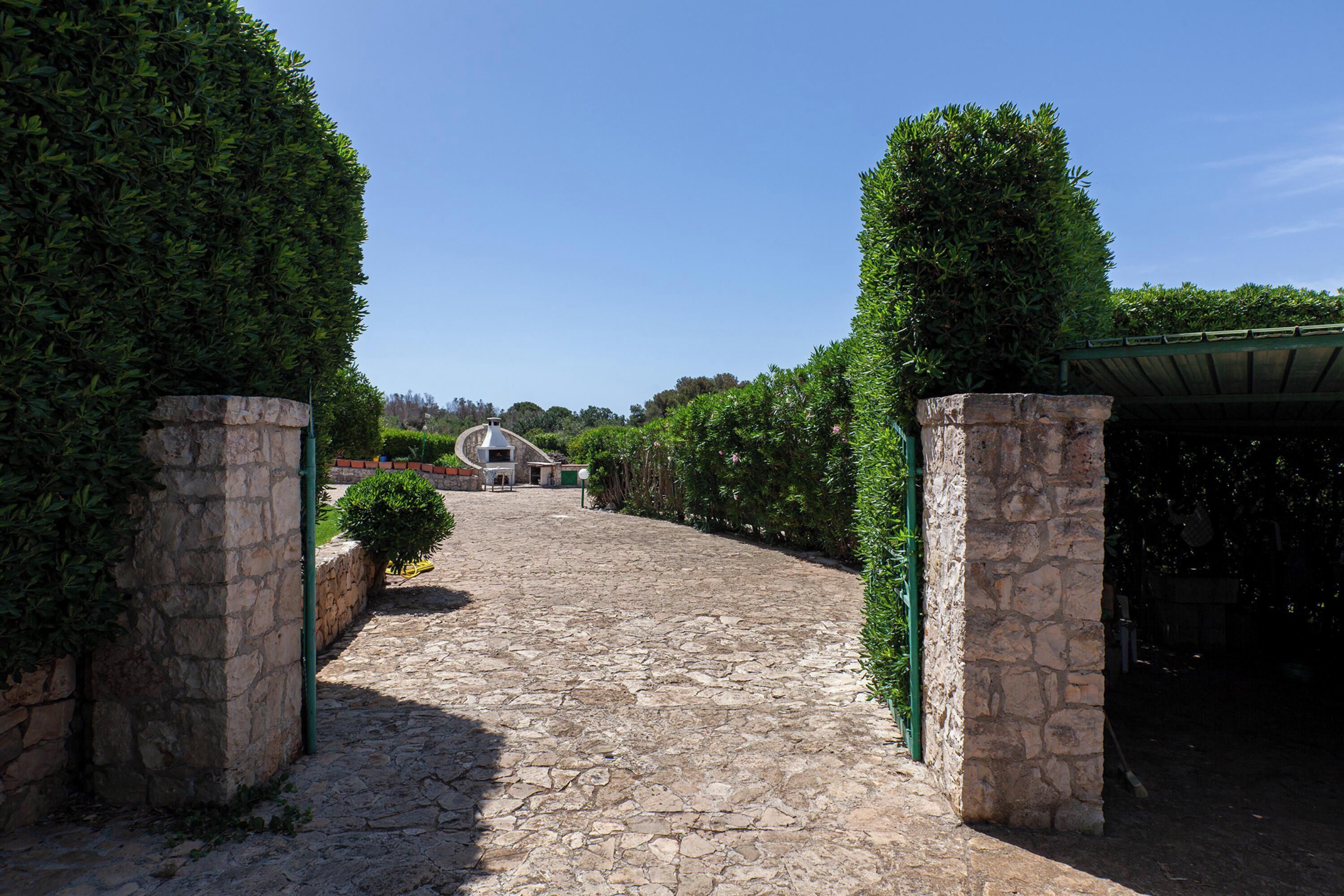 Um caminho de pedra leva a um edifício com entrada coberta.