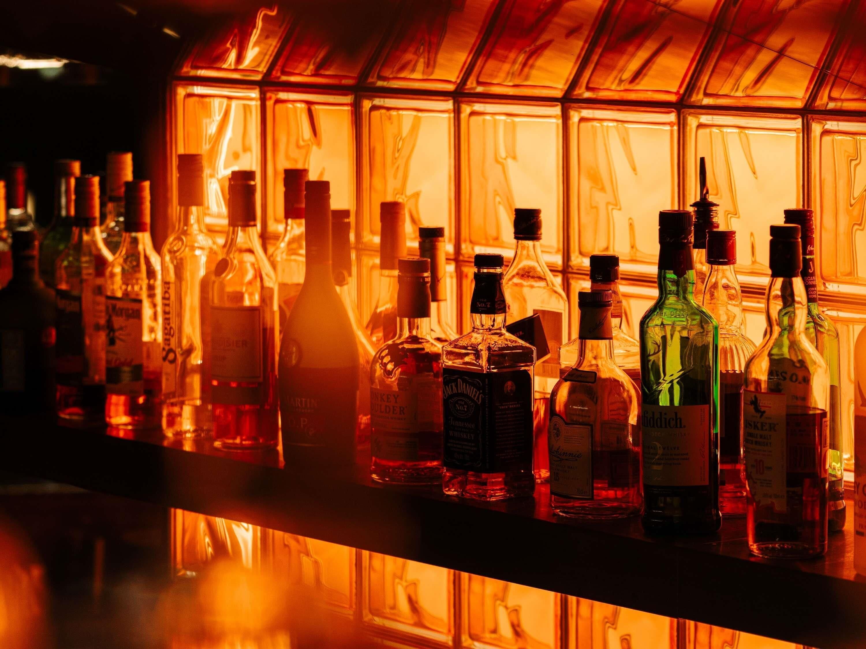 Um balcão com diversas garrafas de bebidas alcoólicas.