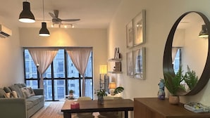 Uma sala de estar moderna com um sofá, uma mesa de jantar e um espelho grande.