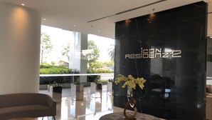 Um lobby moderno com parede de mármore preto exibindo o texto "ICON RESIDENCE 2".