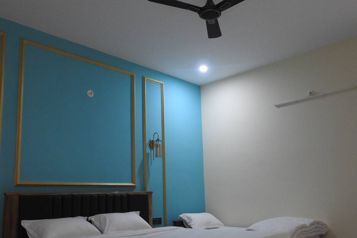 Quarto com uma cama, um ventilador de teto e um espelho.