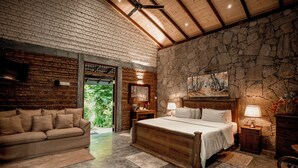 Quarto com parede de pedra, cama de madeira, parede de tijolo e teto de madeira.