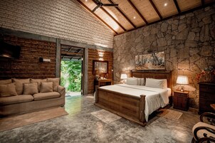 Quarto com parede de pedra, cama de madeira, parede de tijolo e teto de madeira.