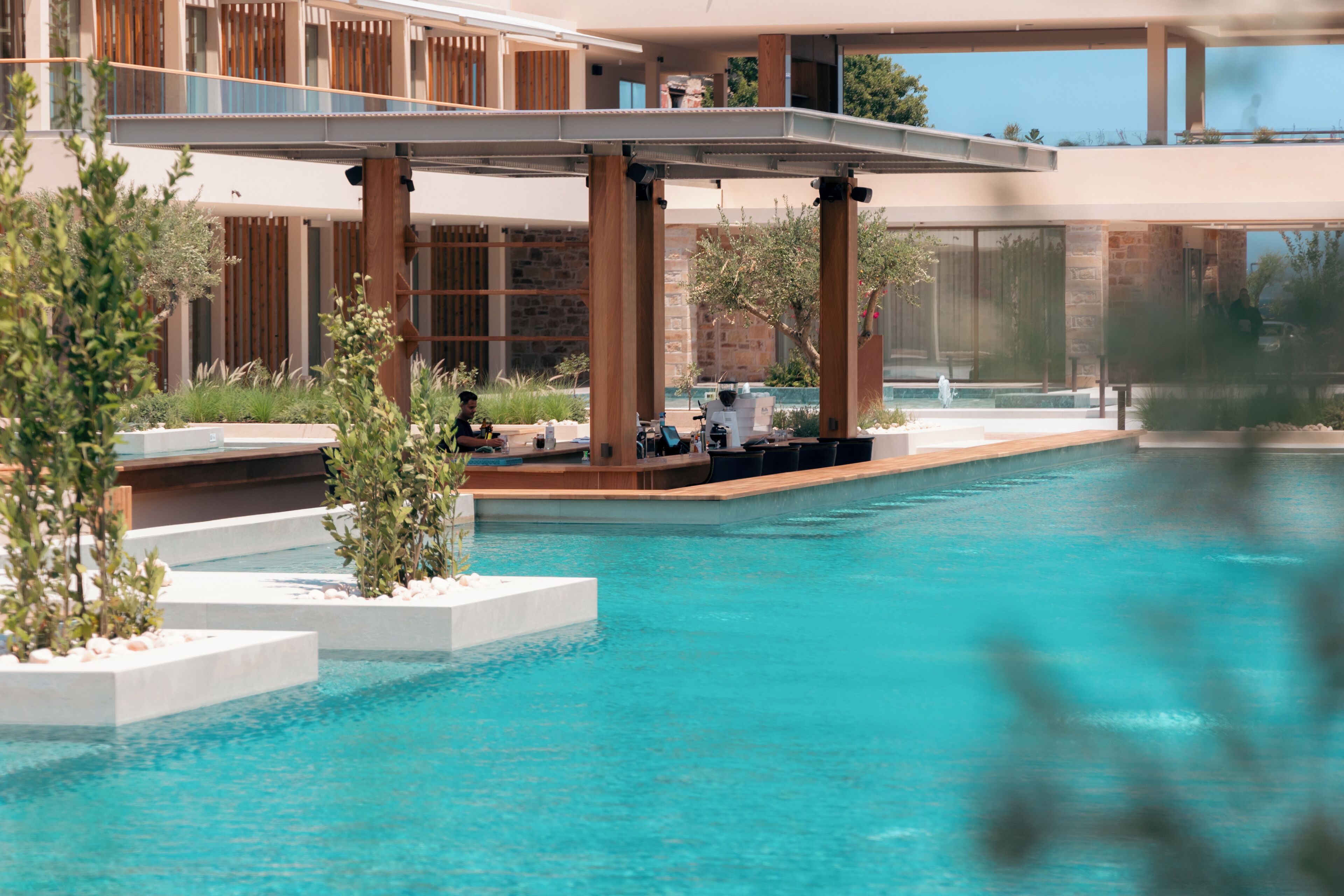 Uma área de piscina moderna com vista clara, assentos de lounge e arquitetura ao redor.
