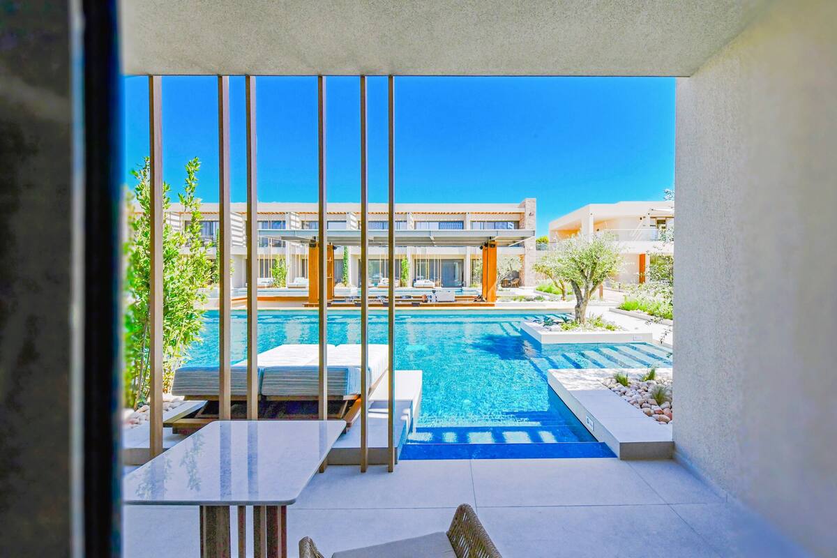Um hotel moderno com área de piscina, incluindo espreguiçadeiras e vista clara da piscina.