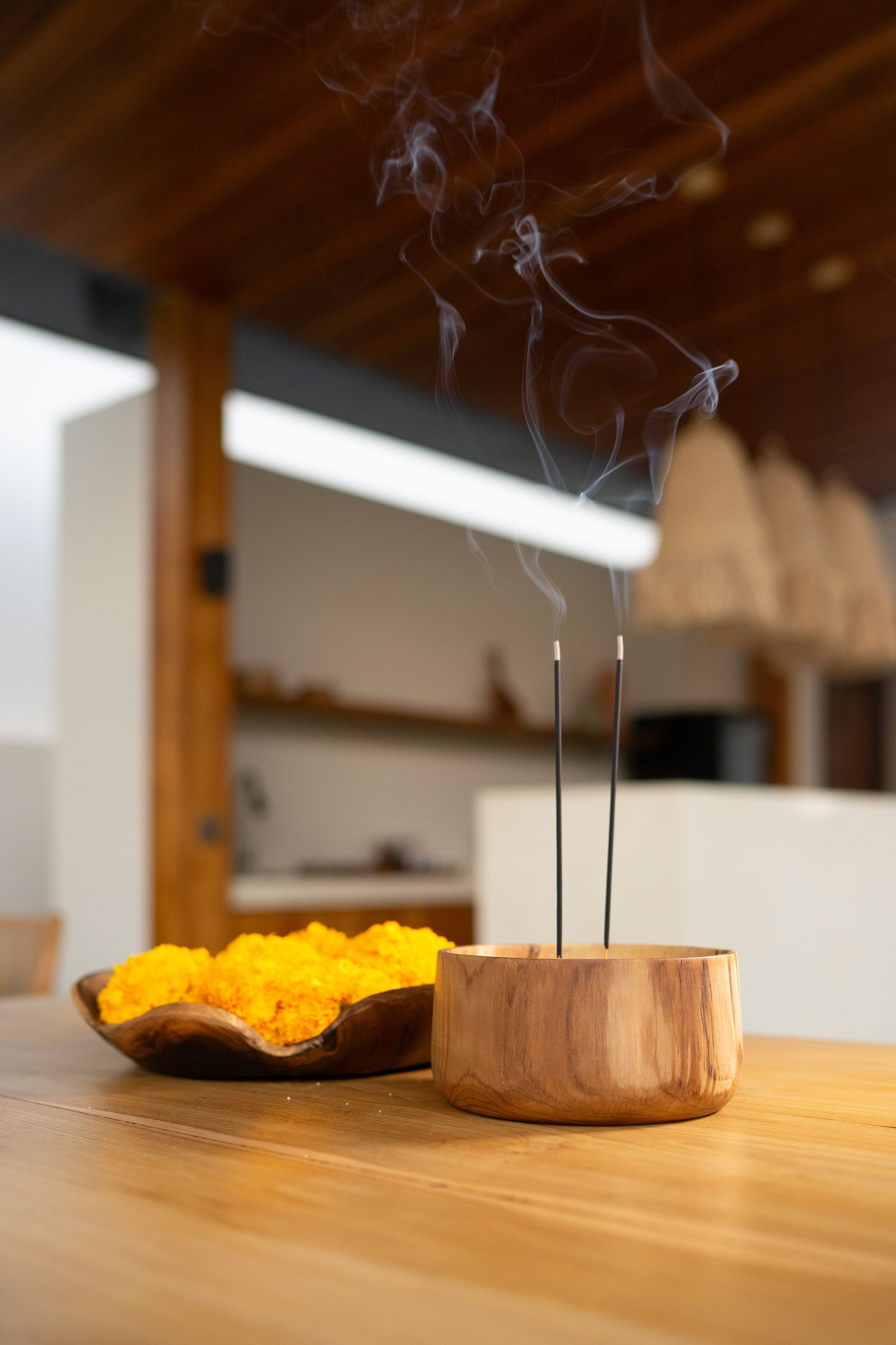 Um queimador de incenso de madeira com incensos sobre uma mesa de madeira.
