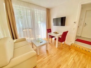 Apartamento luxo, 1 cama Queen, varanda, no piso térreo | Área de estar | Smart TV 43 polegadas com canais a cabo