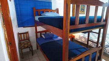 Quarto com beliche, teto de madeira e uma cadeira pequena.