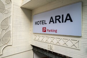Placa do Hotel Aria com símbolo de estacionamento.