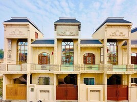 Um edifício com vários andares e detalhes arquitetônicos elaborados, incluindo colunas decorativas e varandas.