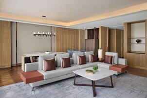Uma sala de estar moderna com sofá seccional, mesa de centro e um espaço de jantar com mesa e cadeiras.