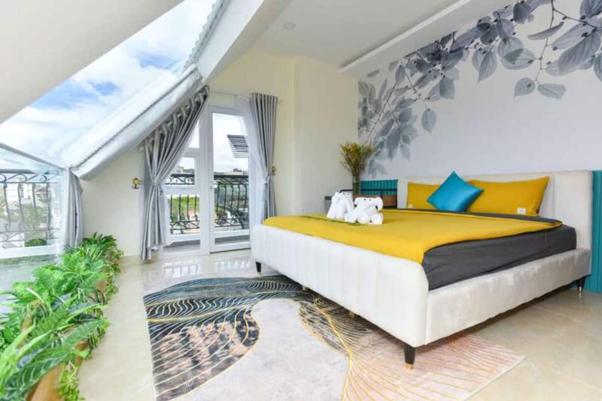 Quarto com cama, vista para o exterior e um claraboia.