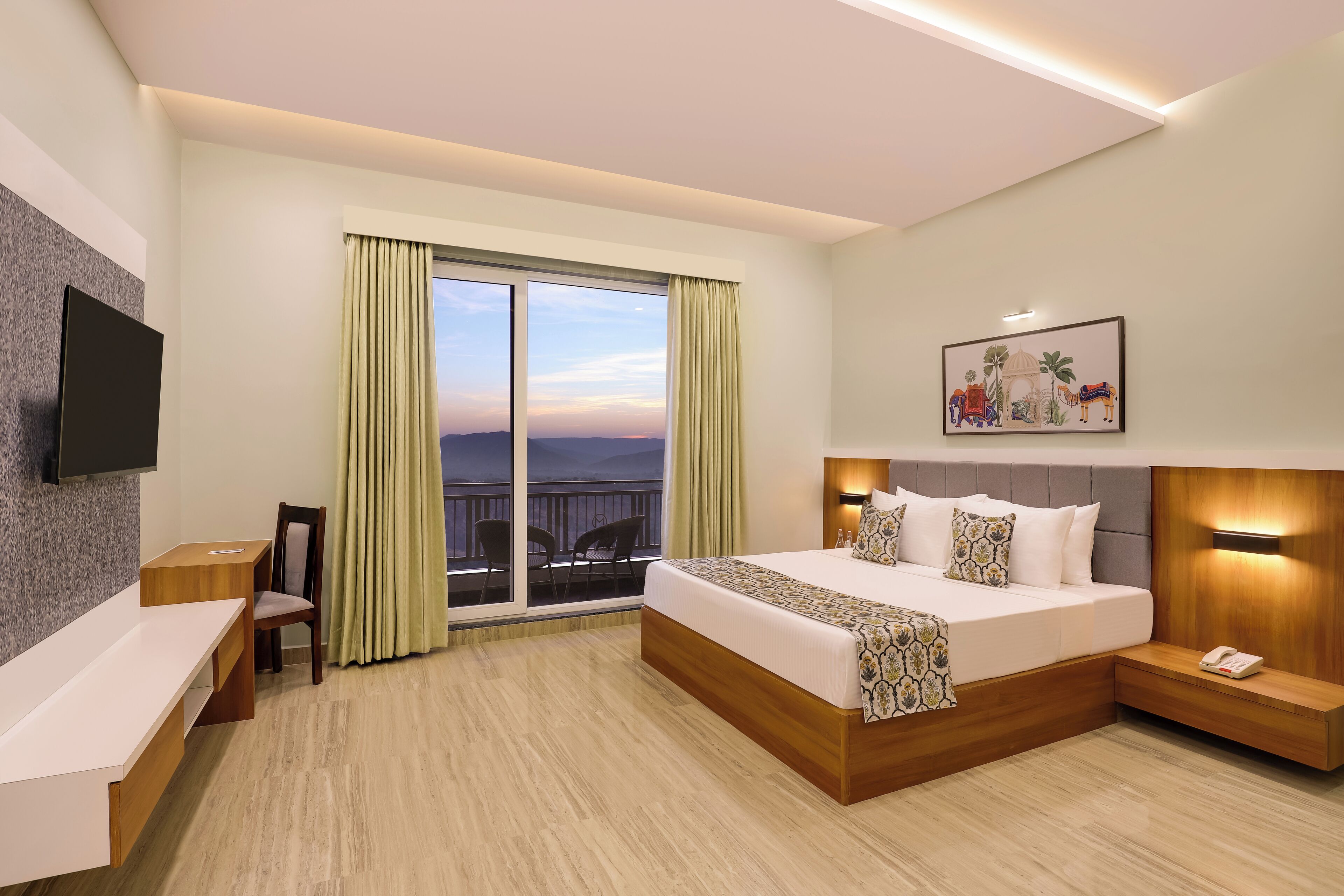 Quarto de hotel com uma cama grande, uma escrivaninha, uma cadeira, televisão, mesa de cabeceira, telefone e janela com cortinas.