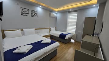 Quarto triplo standard | Roupas de cama premium, frigobar, individualmente mobiliados