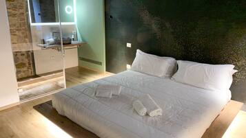 Quarto moderno com uma cama grande, um espelho embutido em toucador e uma parede decorada com pedra.