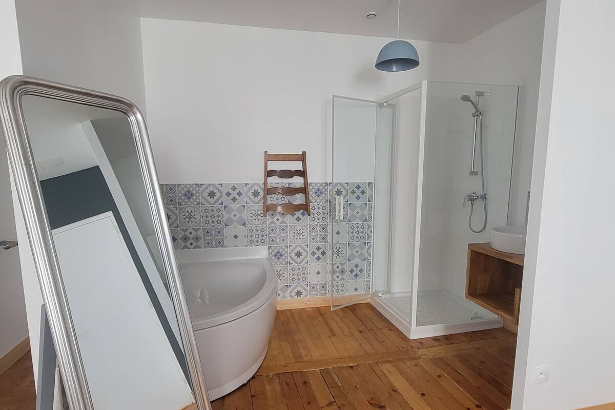 Uma casa de banho com chuveiro, sanita e banheira.