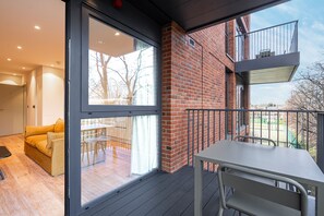 Um apartamento moderno com varanda, janelas amplas e área de jantar.