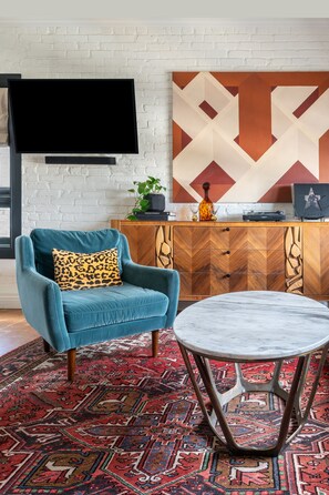 King Apartment | Área de estar | TV LED 42 polegadas com canais digitais, livros, smart speakers