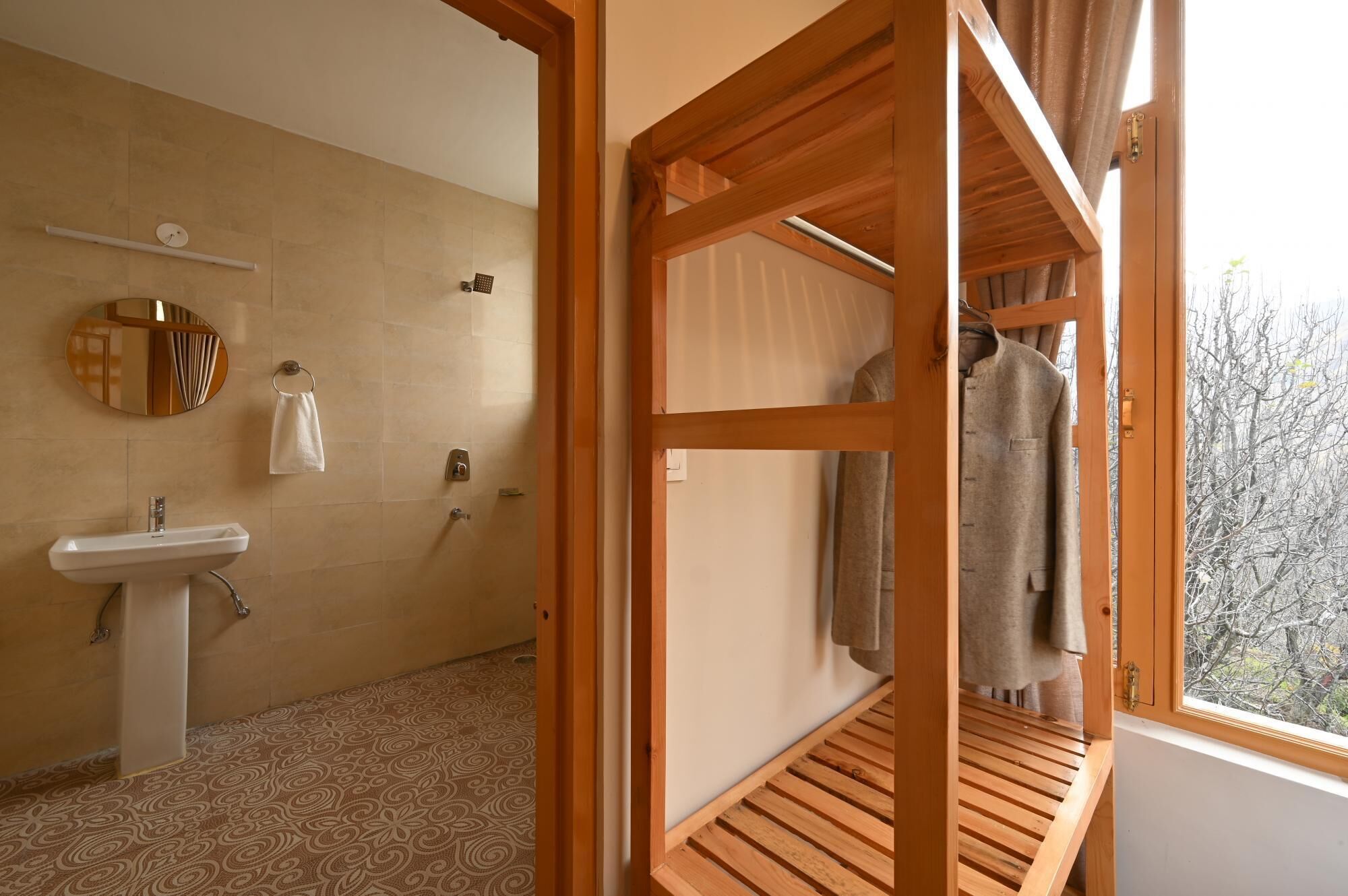 Casa de banho com lavatório, espelho, porta-toalhas e beliches de madeira.