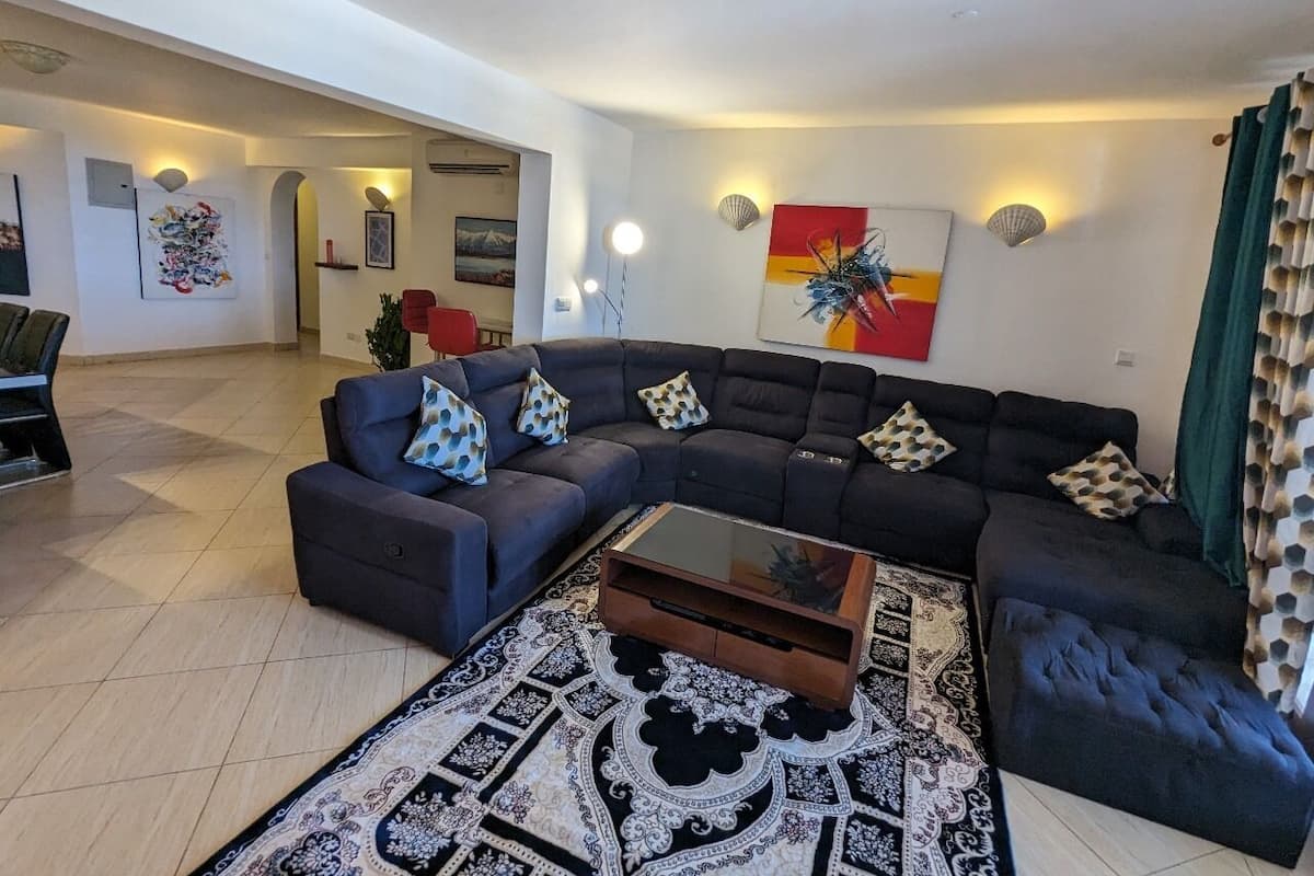 Uma sala de estar moderna com um sofá seccional, uma mesa de centro e um tapete estampado.