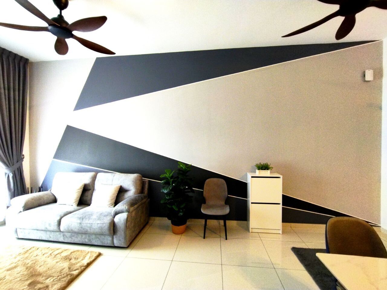 Uma sala de estar moderna com um sofá, uma poltrona, uma mesinha e um armário.
