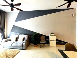 Uma sala de estar moderna com um sofá, uma poltrona, uma mesinha e um armário.