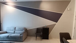 Uma sala de estar moderna com um sofá, cadeiras e uma mesinha.