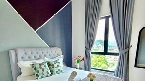 Quarto moderno com cama, ventilador de teto, janela com cortinas e vista para o verde lá fora.