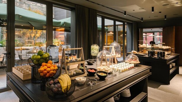 Buffet montado com diversos alimentos e vista para o exterior.