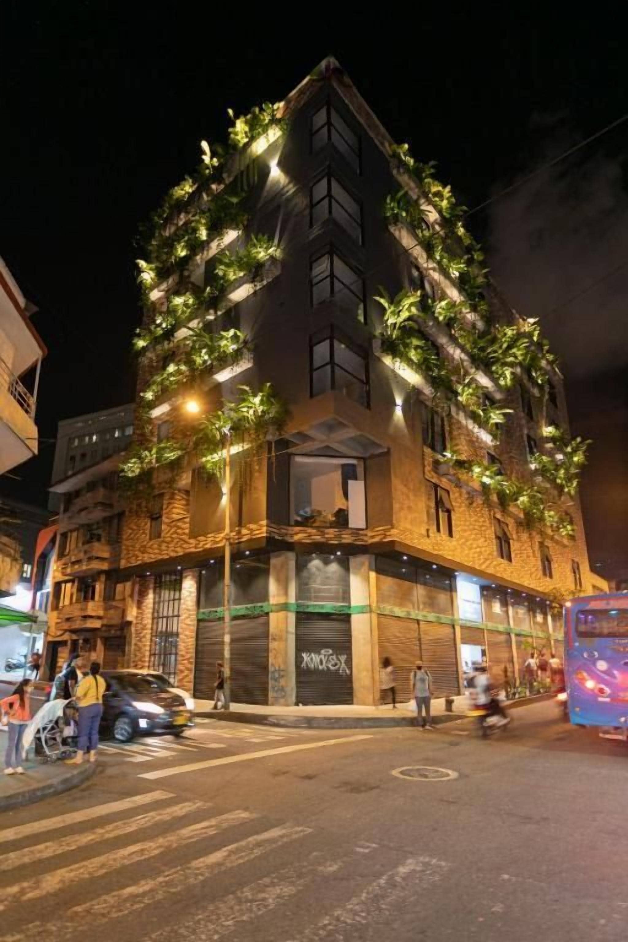 Um edifício com design arquitetônico único e jardins verticais na fachada.
