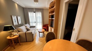 Uma sala de estar moderna com sofá, mesa de centro e rack para TV.
