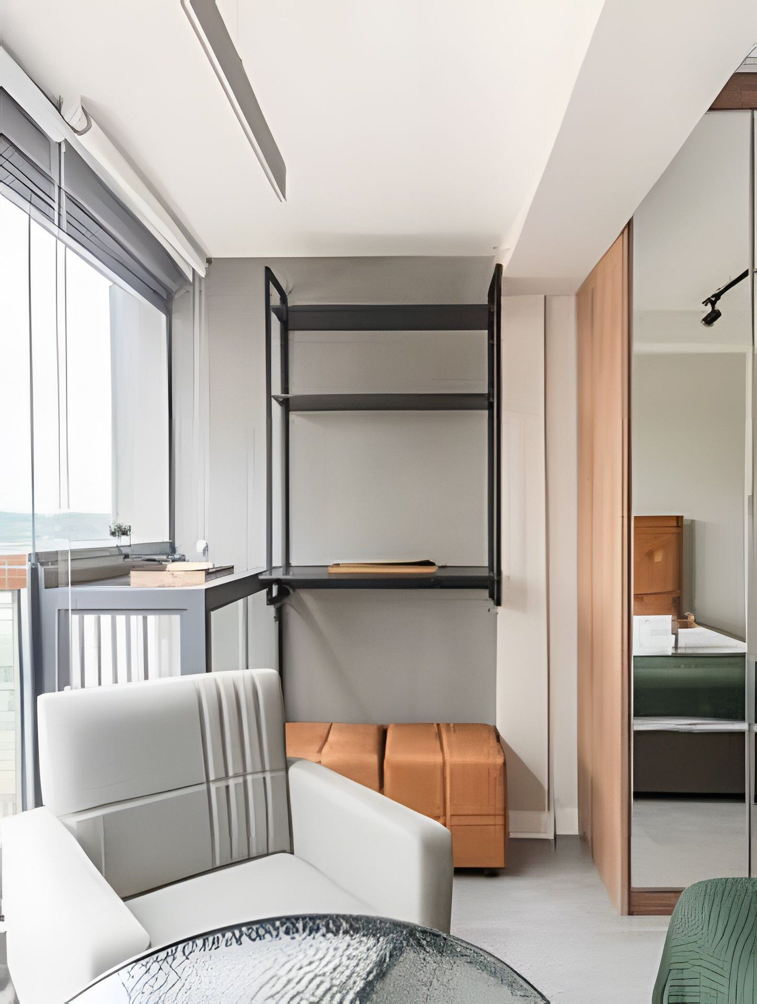 Quarto moderno com cama embutida, área de estar e uma pequena mesa.