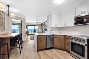 Uma cozinha moderna com máquina de lavar louça, forno e vista para o exterior.