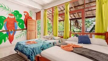 Quarto com duas camas, um mural de araras e vista para o verde através de grandes janelas.