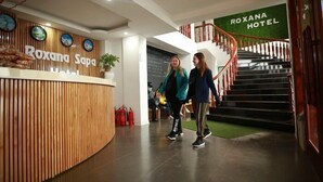 Uma receção com a placa 'Roxana Sapa' e uma escadaria que dá para o andar superior.