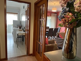 Cozinha com área de refeições, um vaso com flores e vista para a sala de jantar.