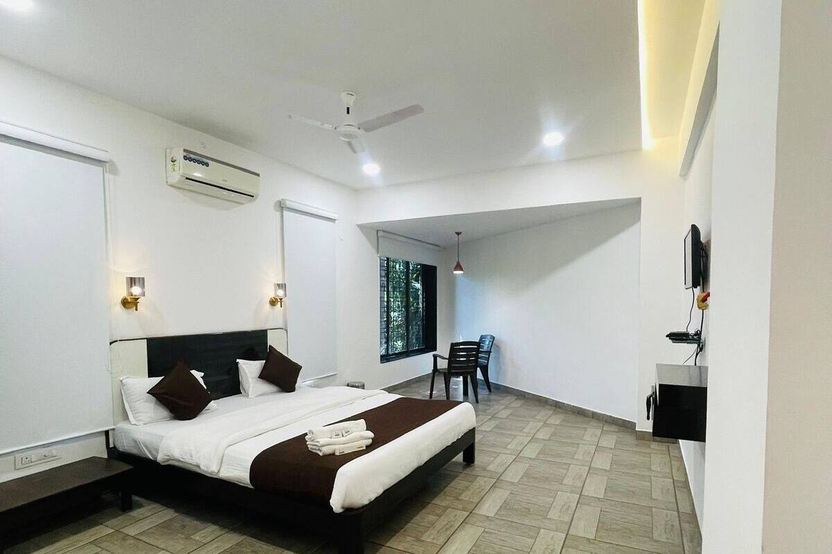 Quarto de hotel moderno com uma cama grande, uma escrivaninha e uma cadeira.