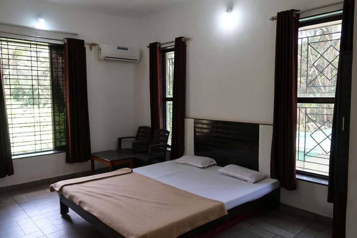 Quarto com cama, escrivaninha e duas cadeiras.