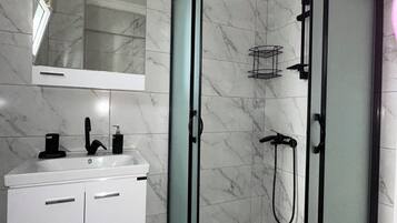 Apartamento básico | Banheiro | Chuveiro, toalhas de banho, papel higiênico