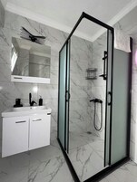 Apartamento básico | Banheiro | Chuveiro, toalhas de banho, papel higiênico