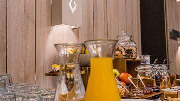 Uma mesa de buffet com diversas opções de comida e um jarro amarelo de suco.
