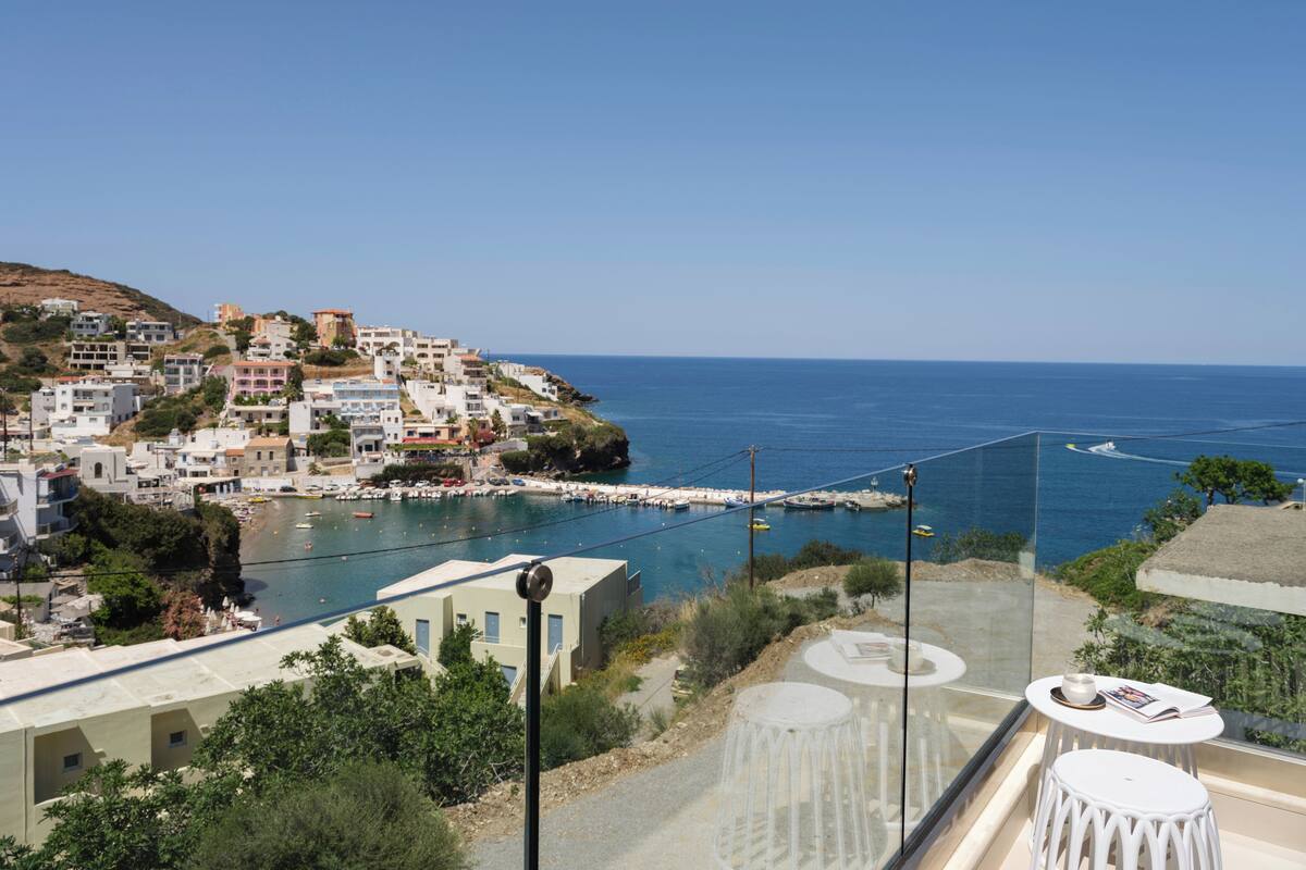 Uma vila costeira com edifícios numa encosta com vista para o mar.