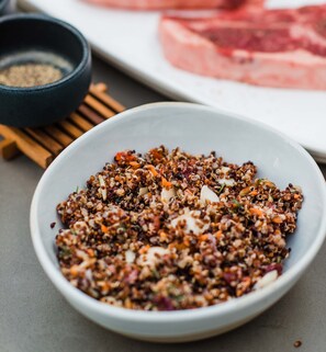 Uma salada de quinoa em uma tigela, com ingredientes visíveis como nozes e vegetais.