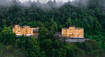Edifícios altos cercados por uma floresta densa.