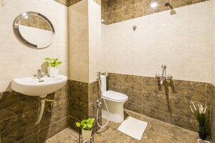 Casa de banho com lavatório, sanita e chuveiro.