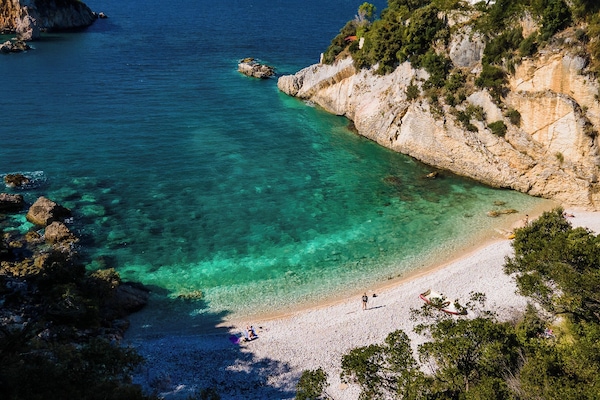 Uma praia privada, praia de areia negra, espreguiçadeiras