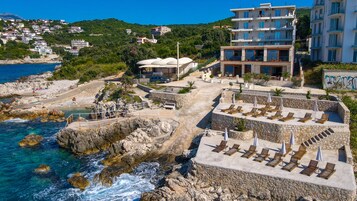 Um hotel à beira-mar com uma costa rochosa, área de estar ao ar livre e vista para o mar.