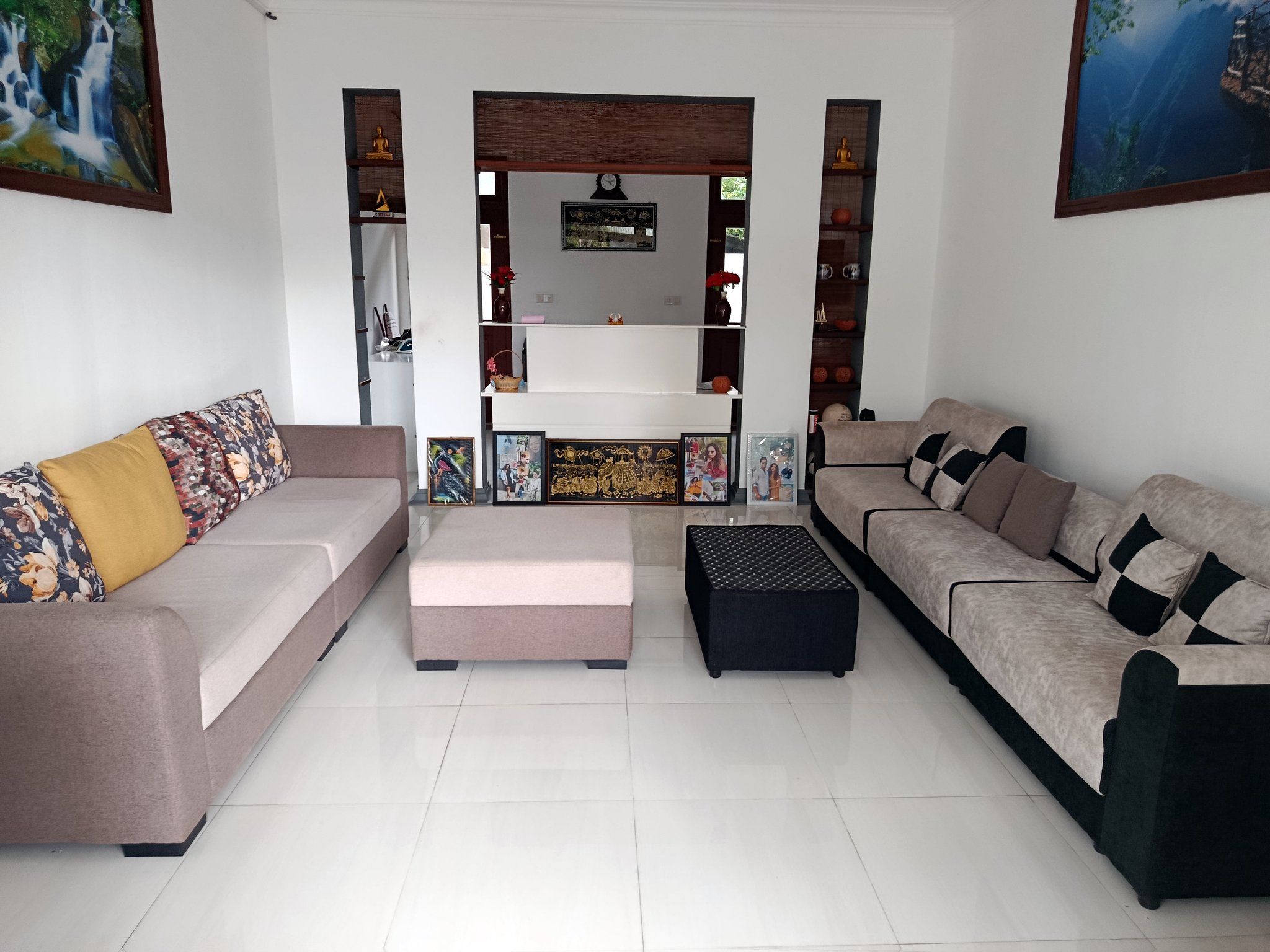 Sala de estar com dois sofás, uma mesa de centro e uma estante decorativa.